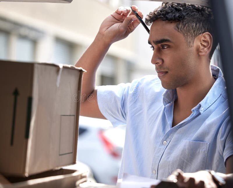 Am I Missing a Box. Shot of a Young Delivery Man Checking Boxes in a ...