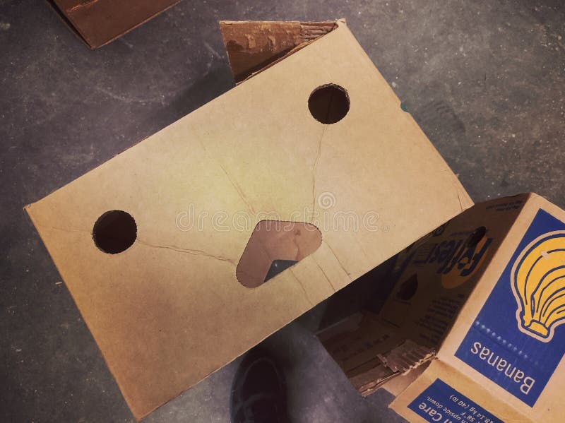 I See Faces. Cardboard Box in a Warehouse. the Holes in the Box Give ...