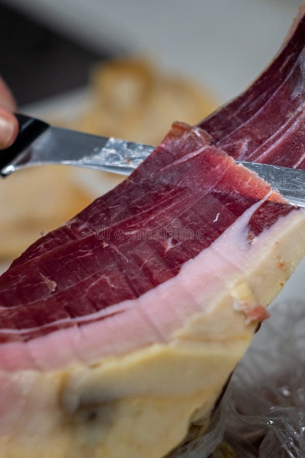 Iberian Ham Cut into Small Slices with a Knife. Stock Photo - Image of ...