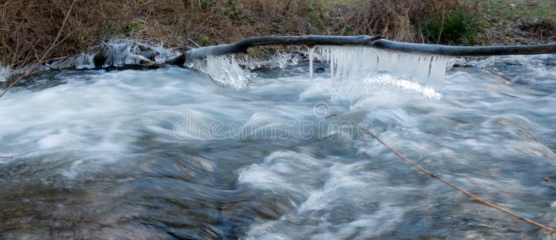 Ice on a Branch Hanging Over a Creek Stock Photo - Image of iced ...