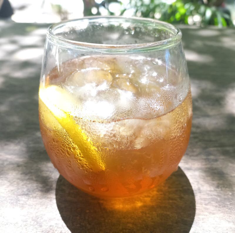 Ice Cold Iced Tea with Lemon Wedges, Drips on Glass, Colored Shadows ...