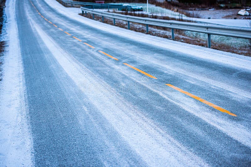 Ice Covered Road with Tire Tracks and Yellow Road Markings Stock Image ...