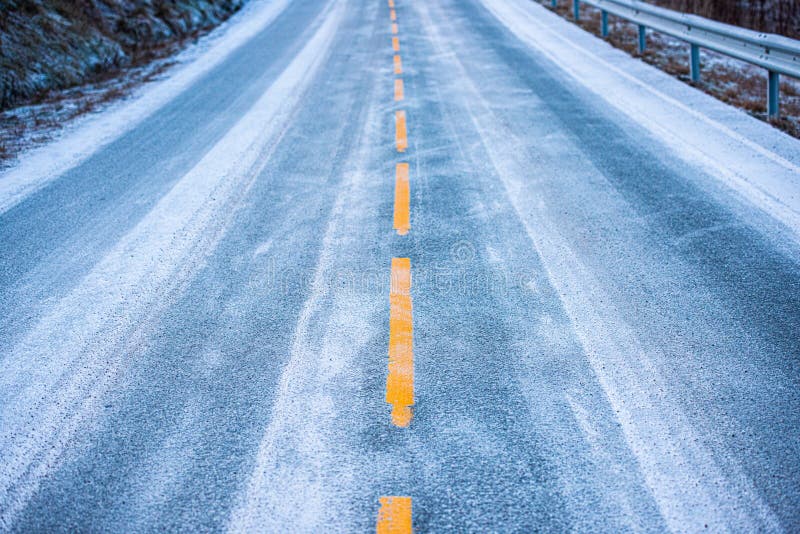 Ice Covered Road with Tire Tracks and Yellow Road Markings Stock Image ...