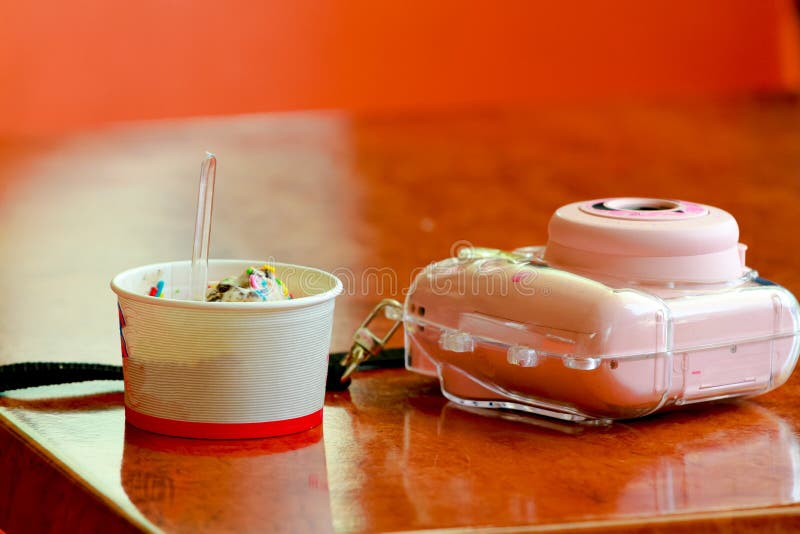 Ice Cream in a Cup and Camera on a Wooden Table. Stock Photo - Image of ...