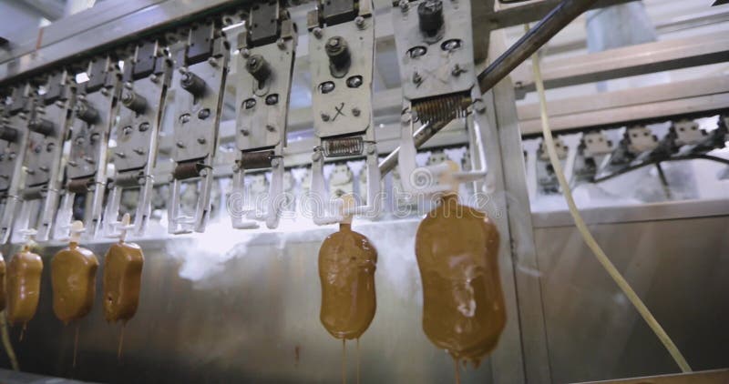 Ice Cream is Dipped into Melted Chocolate Close-up. Chocolate Dripping ...