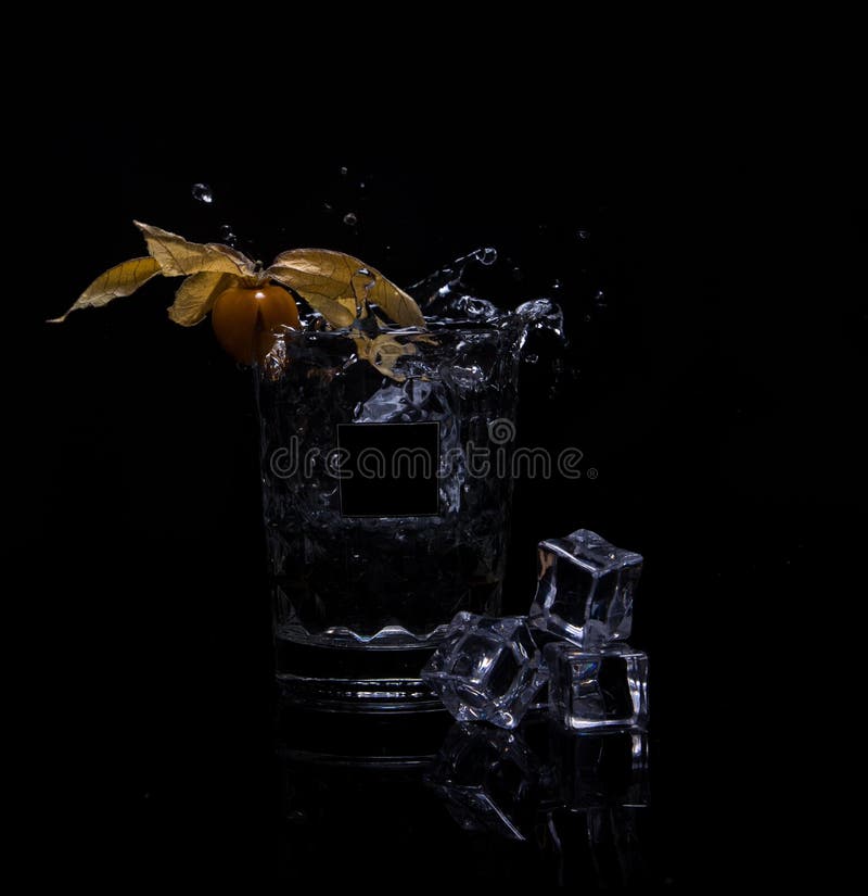 Splashing Drink on a Black Background with a Physalis Stock Photo ...