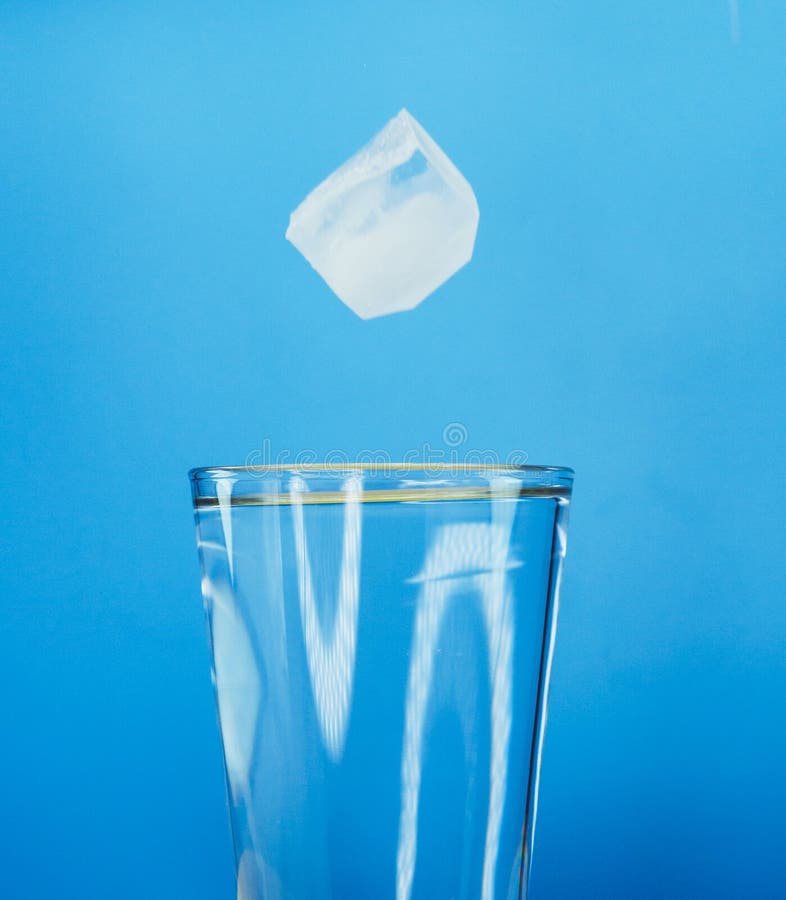An Ice Cube Falls into a Glass of Clean Drinking Water, Splashing it ...