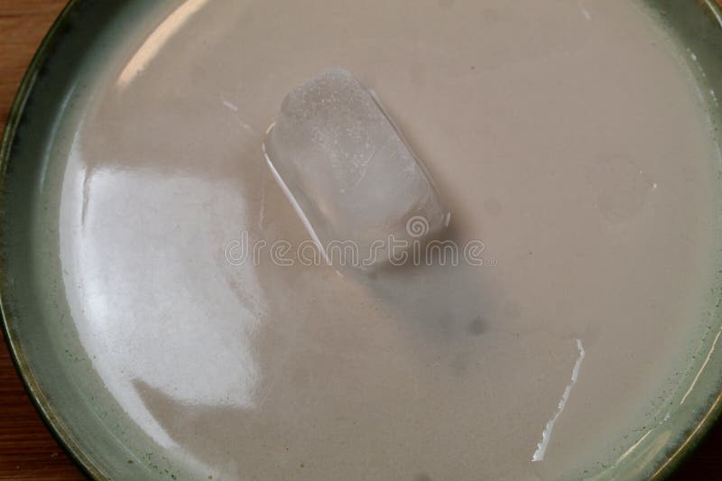 Ice cube melting on plate stock image. Image of design - 286529253