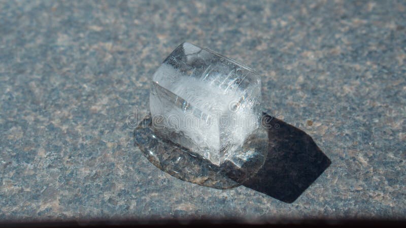 An Ice Cube Melts Under the Bright Light of the Sun on a Stone on a ...