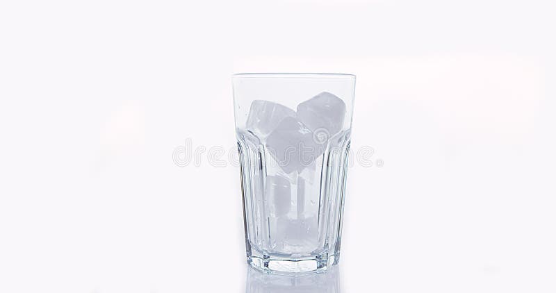 Ice Cubes Falling into Glass Against White Background Stock Photo ...
