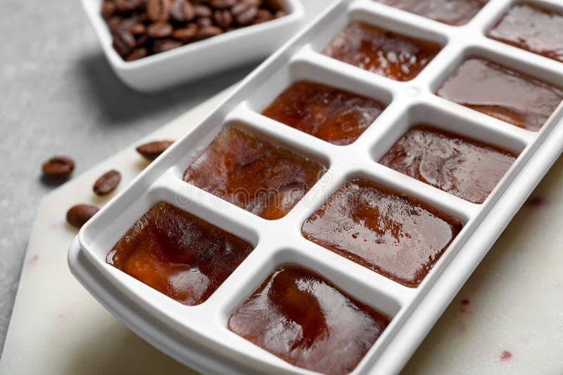 Ice Cubes in Tray and Coffee Beans on Grey Table, Closeup Stock Image ...
