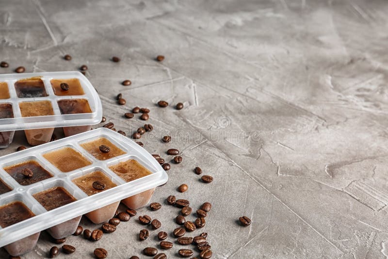 Ice Cubes in Trays and Coffee Beans on Grey Table. Stock Image - Image ...