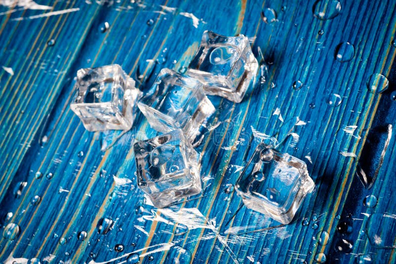Ice Cubes with Water Drops on a Blue Wooden Surface Stock Photo - Image ...