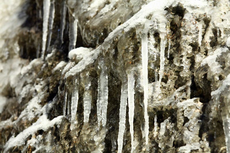 Ice icicles on a rock stock photo. Image of crystal - 170609894