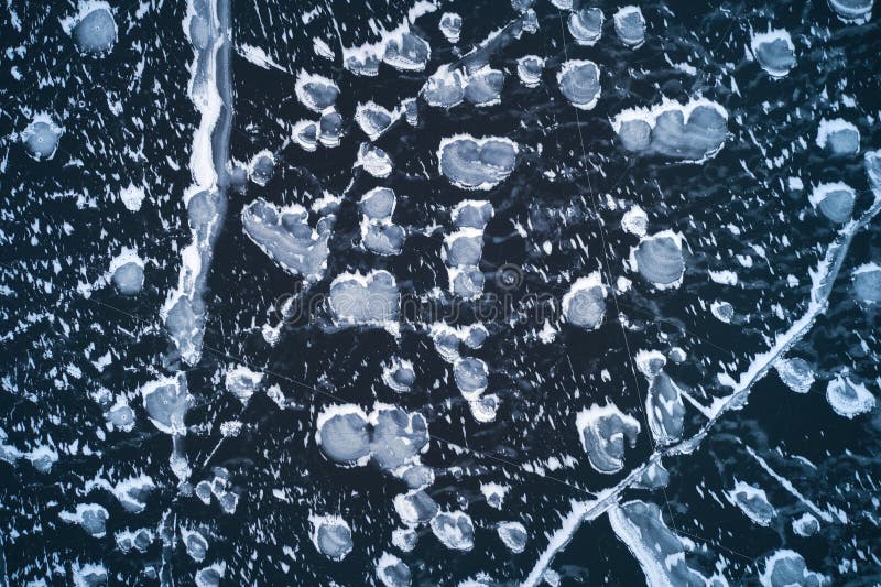 Ice Patterned Surface of Frozen Water Body in Cracks with Light Snow ...