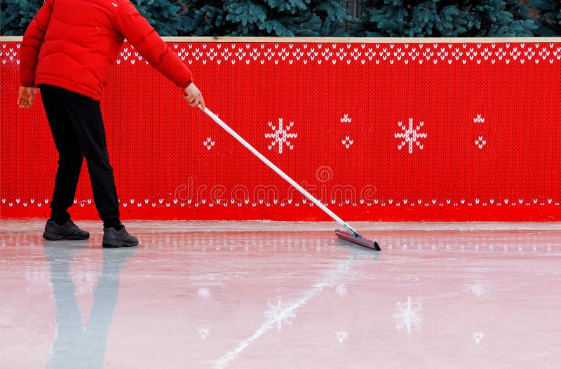 An Ice Stadium Worker in a Red Jacket Cleans the Ice with a Special ...
