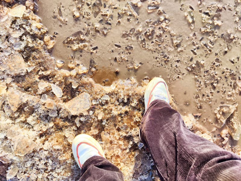 Ice and Water in Spring in Flood. Puddle and Legs of Tourist Person ...