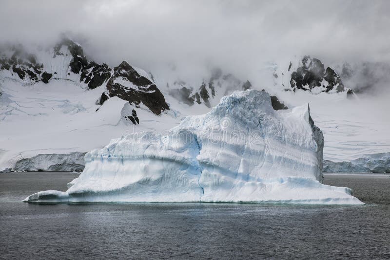 Iceberg with Mountain Backdrop, Antarctica Stock Photo - Image of ocean ...