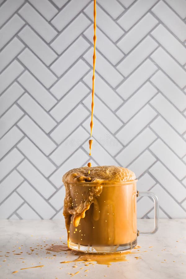 Iced Coffee Falling into an Overflowing Glass Coffee Mug Stock Image ...