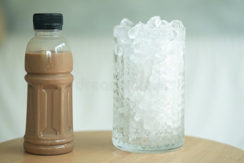 Iced Coffee in Plastic Bottle Served with Ice Cube in Glass Stock Photo ...