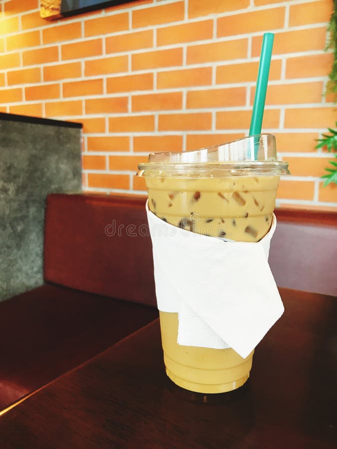 Iced Coffee in Plastic Cup on Wood Table and Brick Wall Background ...