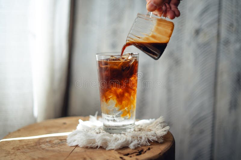Iced Coffee,Pouring a Shot of Coffee into Cold Water in a Glass Stock ...