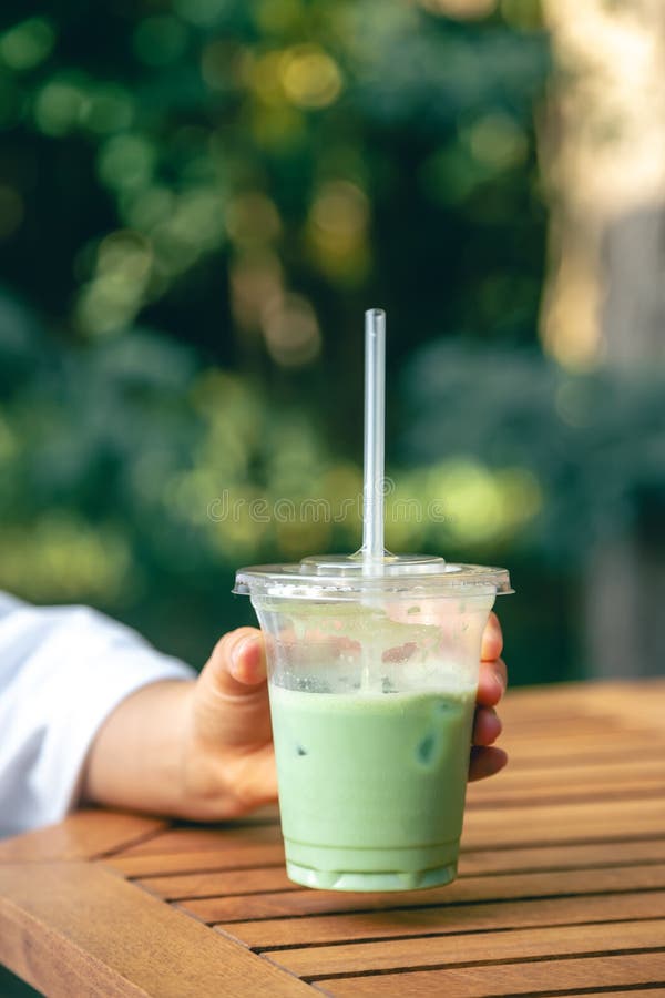 Iced Matcha Latte in a Plastic Cup in Hands of a Woman. Stock Image ...