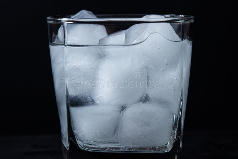 Iced Water in a Glass on a Black Background. Pieces of Ice. Clean ...