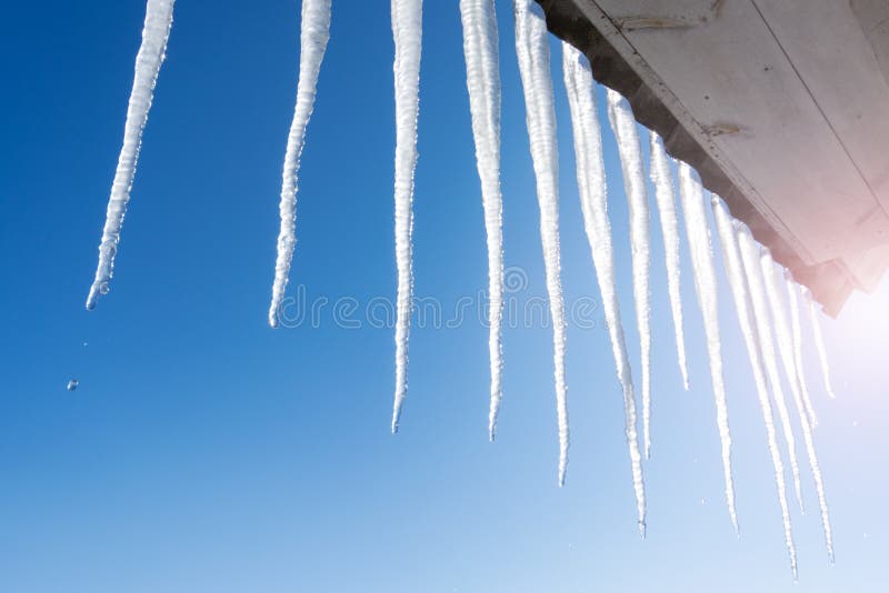Icicles hang from the roof stock photo. Image of january - 260265564