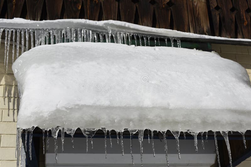 Icicles are Hanging from the Eaves of the Building,covered with a Thick ...