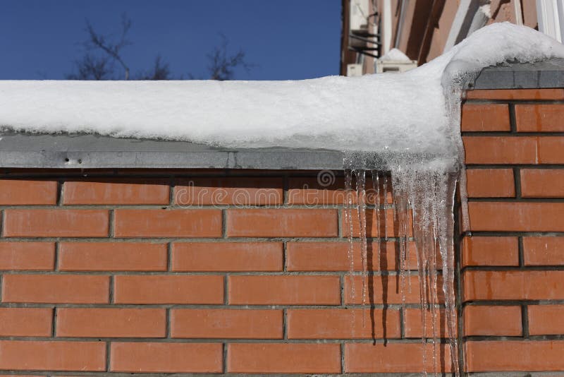 Icicles are Hanging from the Eaves of the Building,covered with a Thick ...