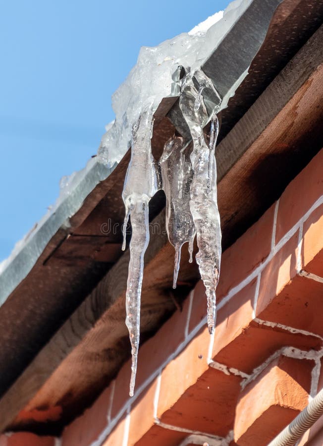 Icicles Hanging from the Roof of a House in Winter Stock Photo - Image ...