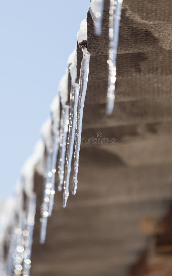 Icicles Hanging from the Roof of a House in Winter Stock Photo - Image ...