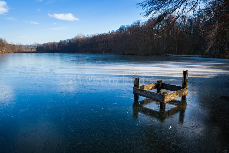 Icy Lake Surroudend by Forest with Blue Sky and Rays of Light on the ...