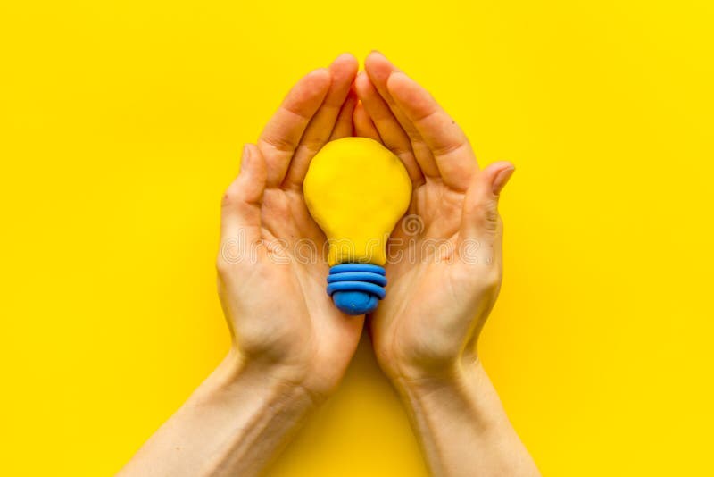 Idea Concept. Bulb in Hands on Yellow Background Top-down Stock Image ...