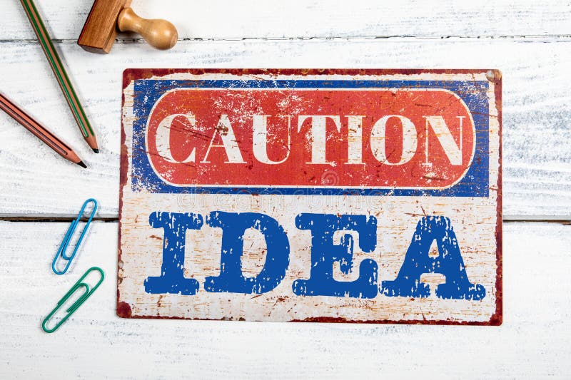 Idea Concept. Metal CAOTION Plate with Text on a White Wooden ...