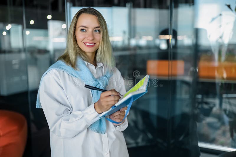 Blonde Smiling Woman Making Notes into a Notebook Stock Image - Image ...