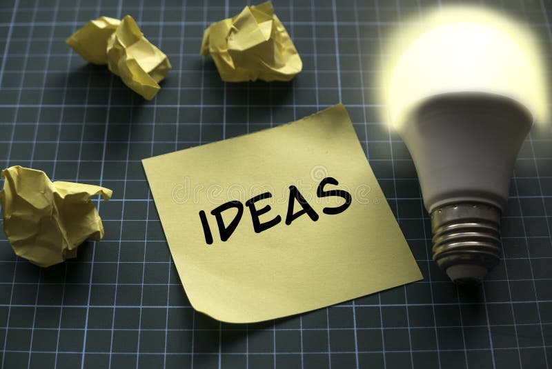 Ideas Concept with a Bright Bulb and Yellow Memo Note on a Green Craft ...