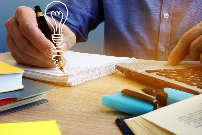 Ideas Concept. Businessman Writing in the Note and Light Bulb. Creative ...