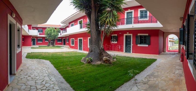 Idyllic Courtyard View of Red Buildings, Lush Greenery, Stone Paths ...