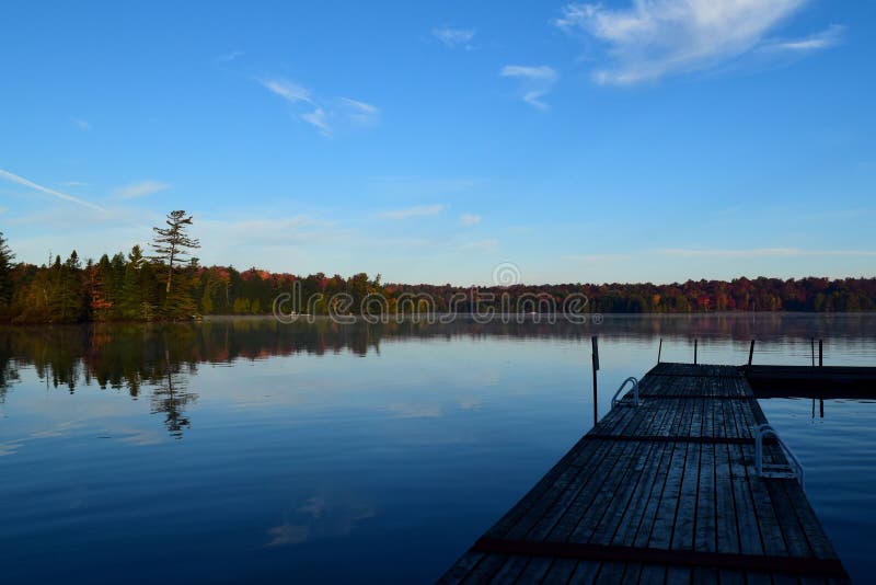 Idyllic Image of an Empty Dock on a Tranquil Lake Surrounded by Lush ...