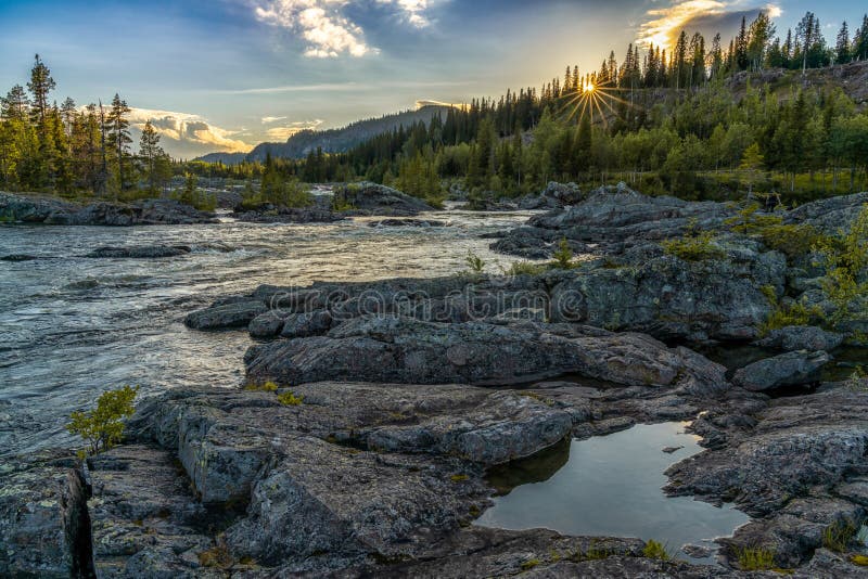 Idyllic River and Pine Forest Landscpe with a Setting Sun and Sun Star ...