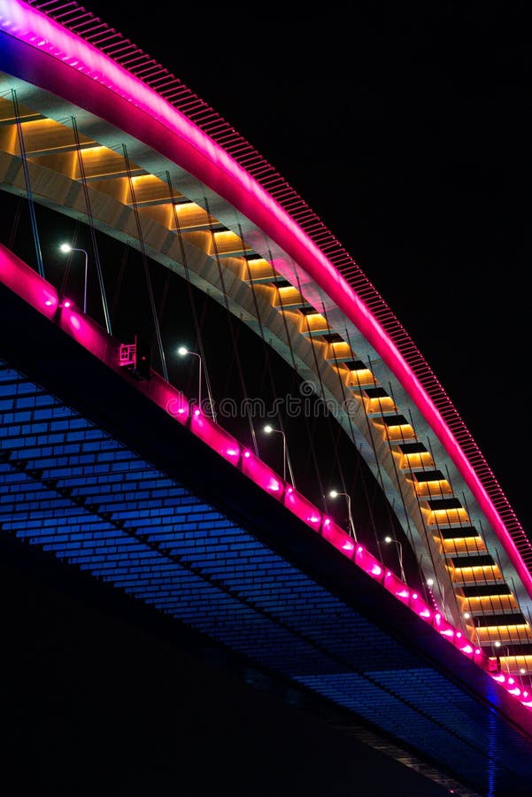 The Illuminated Bridge is Lit Up at Night with Many Different Colors ...