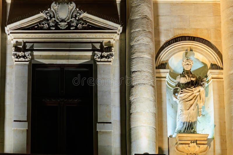 Illuminated Classical Architecture with Ornate Stone Statue at Night ...