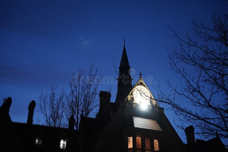 Illuminated Clock on Church Facade at Night on Blue Sky Background ...