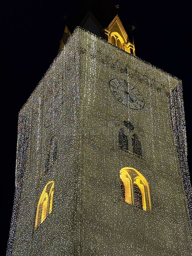 Illuminated Clock Tower at Night with Festive Lights Stock Photo ...