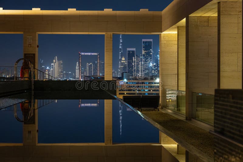 The Illuminated Dubai Skyline Reflecting in a Rooftop Pool at Night ...
