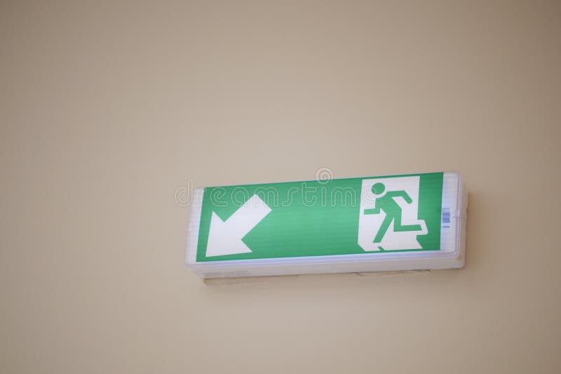 An Illuminated Emergency Exit Sign Featuring a Left Arrow Positioned in ...
