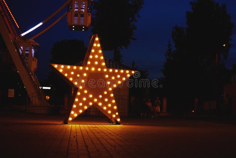Illuminated Glowing Star in Amusement Park at the Night City Stock ...
