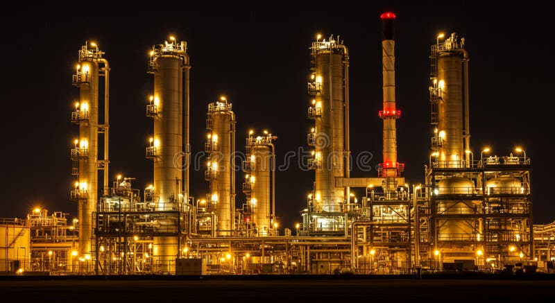 An Illuminated Industrial Refinery is Visible at Night, Featuring a ...